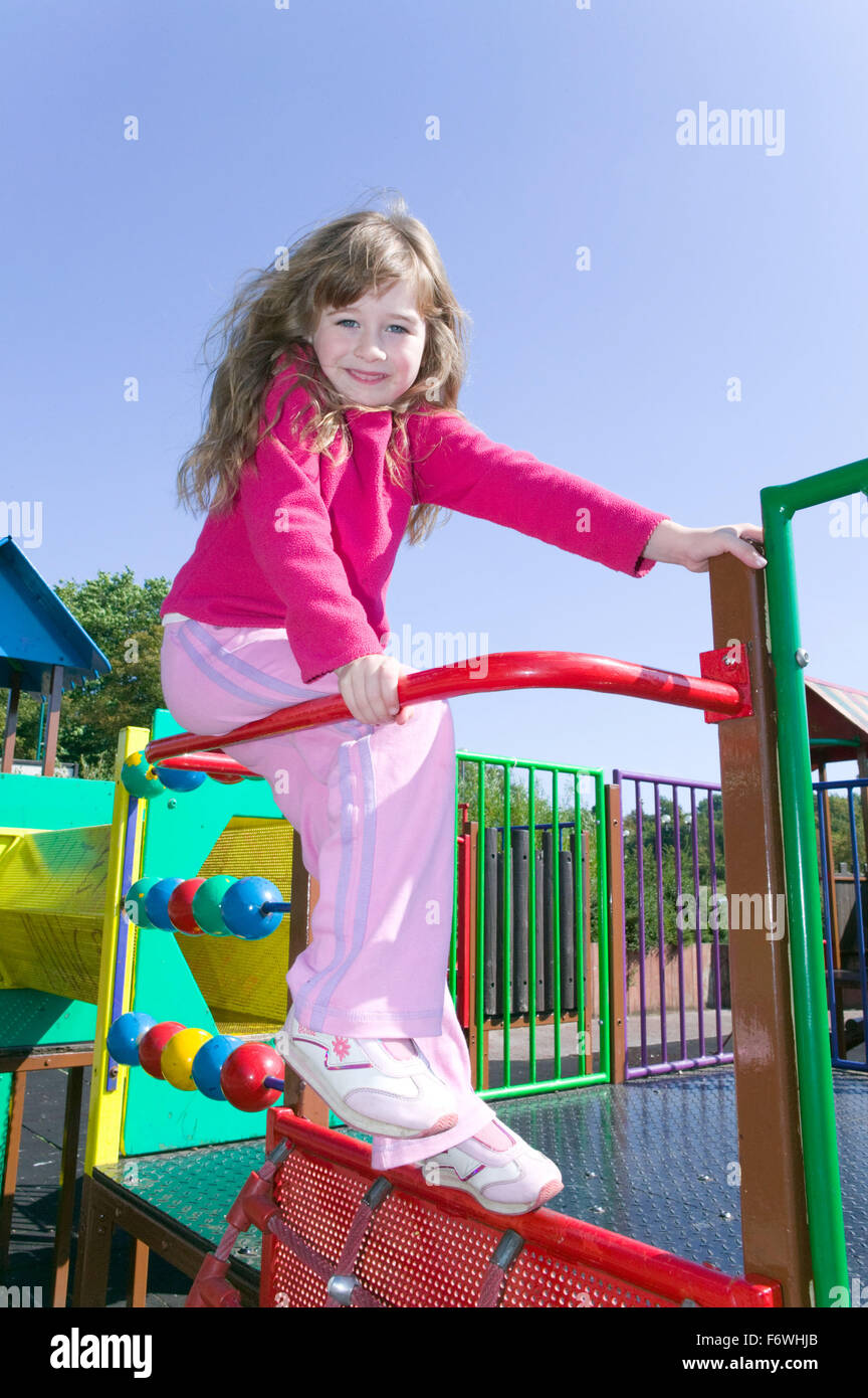 Little girl playing on a climbing frame in the playground Stock Photo ...