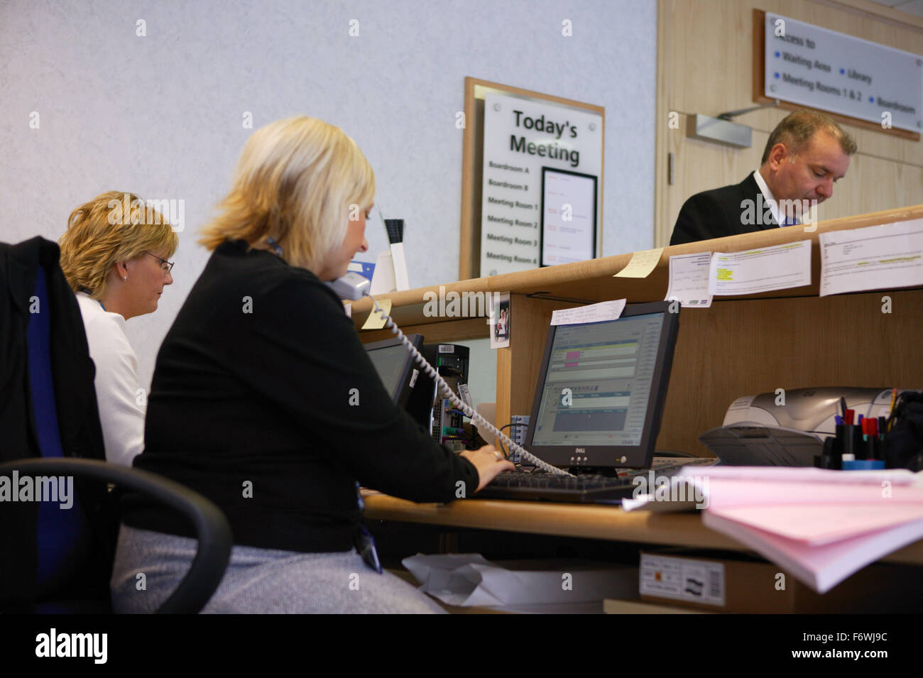 Work colleagues working on reception at the NHS offices Stock Photo - Alamy