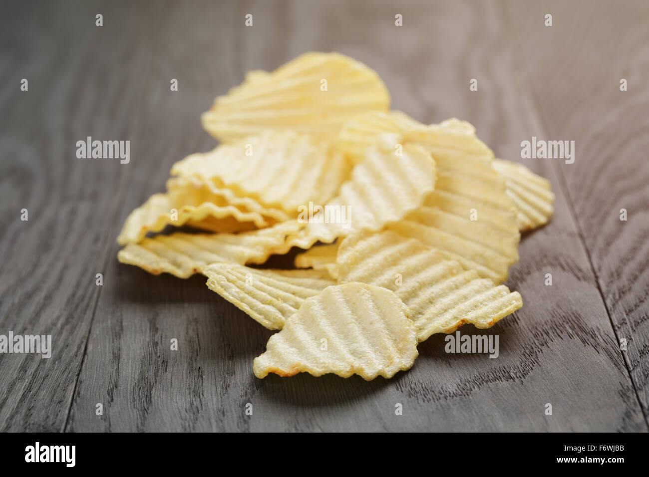 salted potato ships on old wooden table Stock Photo - Alamy