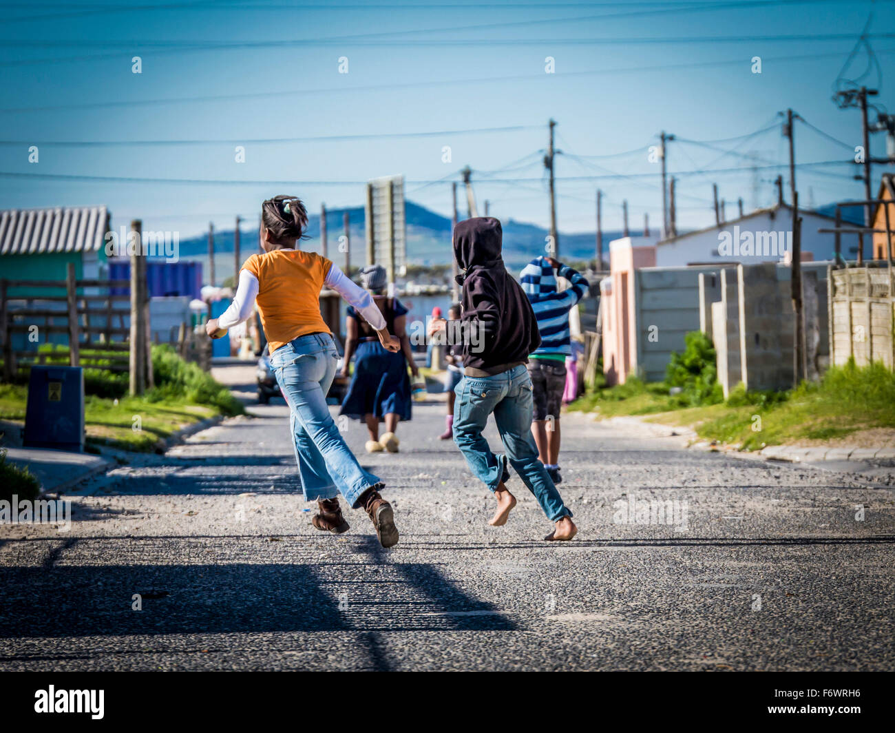 Children running along a street in township Khayelitsha, Cape Town ...