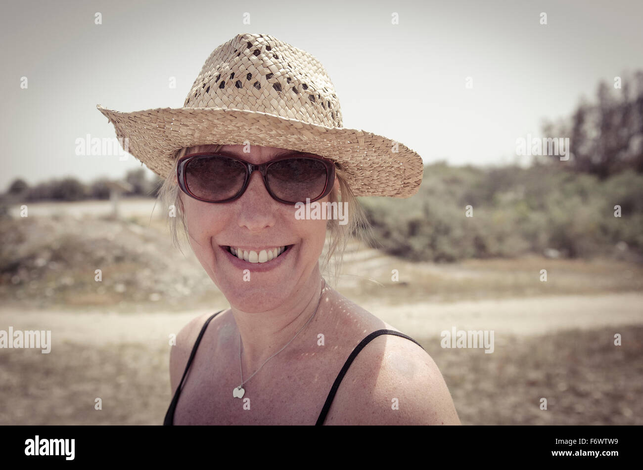 Portrait of a smiling woman wearing a straw hat Stock Photo - Alamy