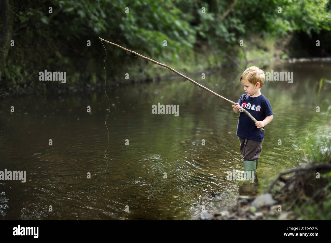 Portrait of a cute little boy fishing in the river Stock Photo - Alamy