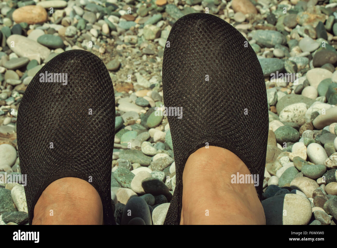 Comfortable black Slippers on the feet of the woman swimming and ...