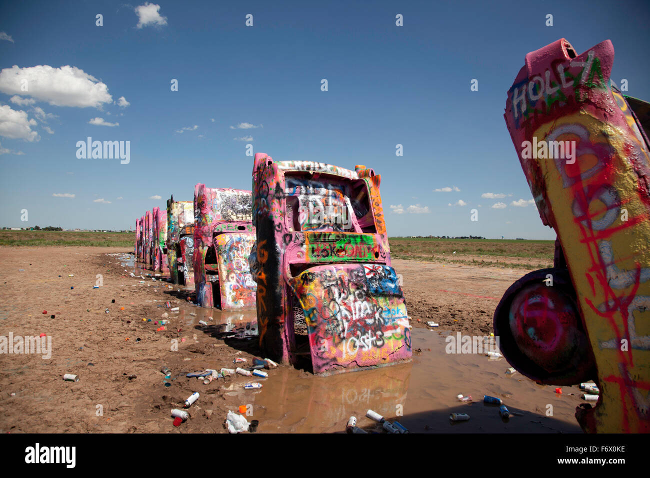 A row of cars surrounded by trash at Cadillac Ranch in Amarillo, Texas ...