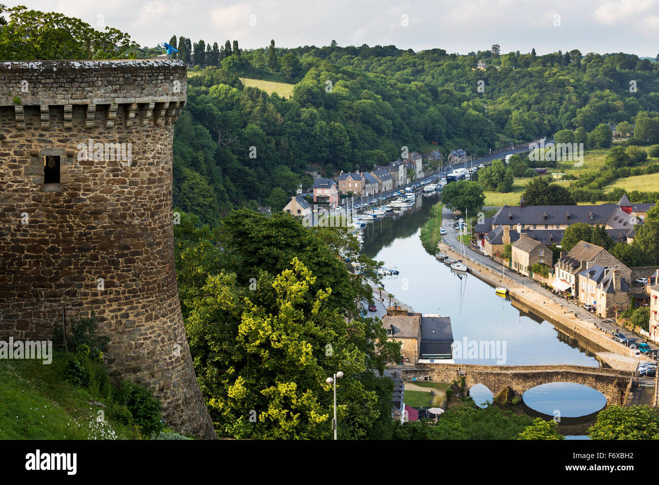 Fortress stone wall turret overlooking riverside treed valley town with ...