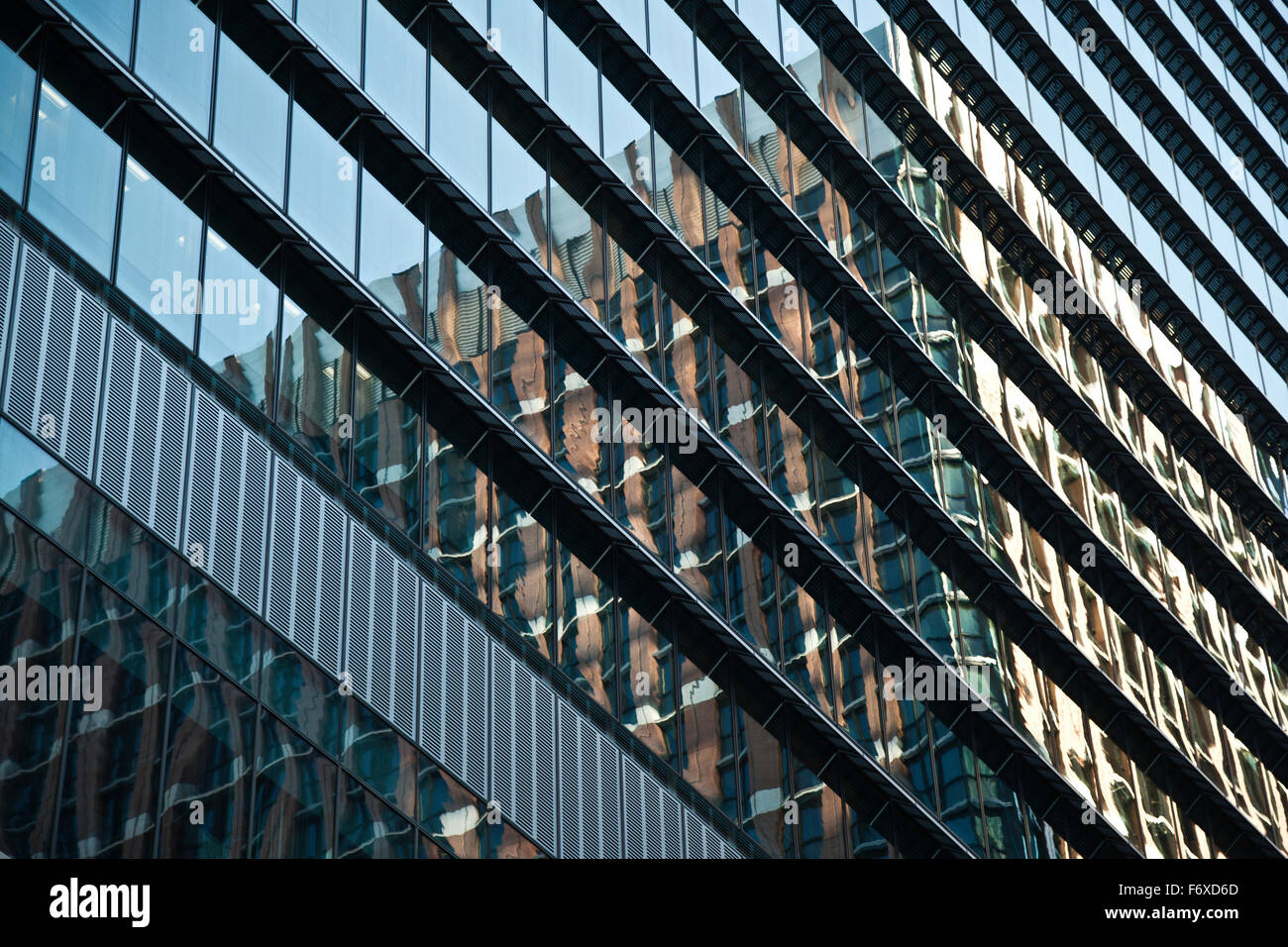 Facade of a building with glass walls and another building reflected in ...