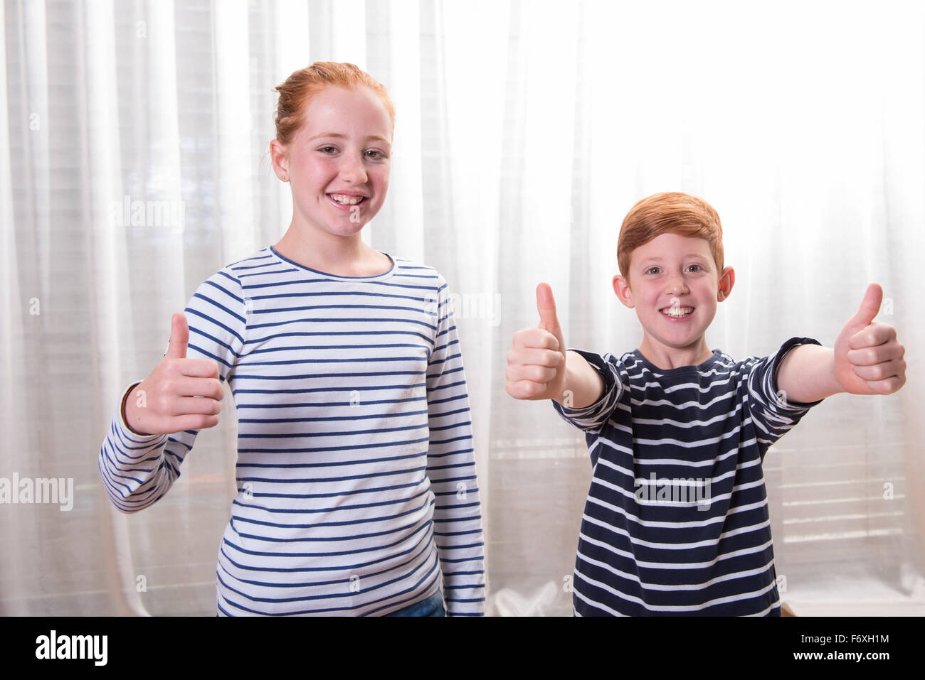 brother and sister smiling and having thumbs up Stock Photo - Alamy