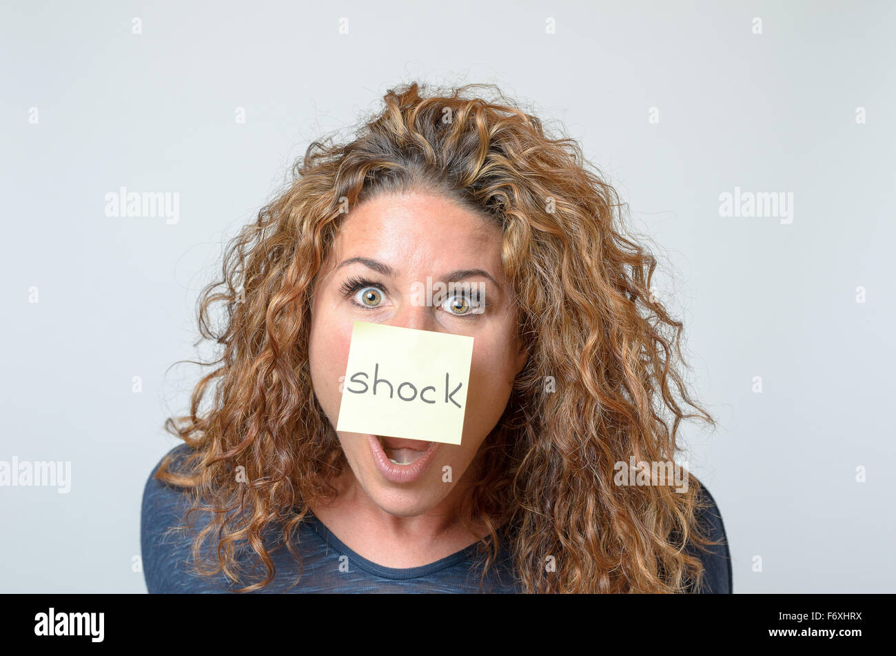 young woman with a sticky note in her face while starring in to the ...