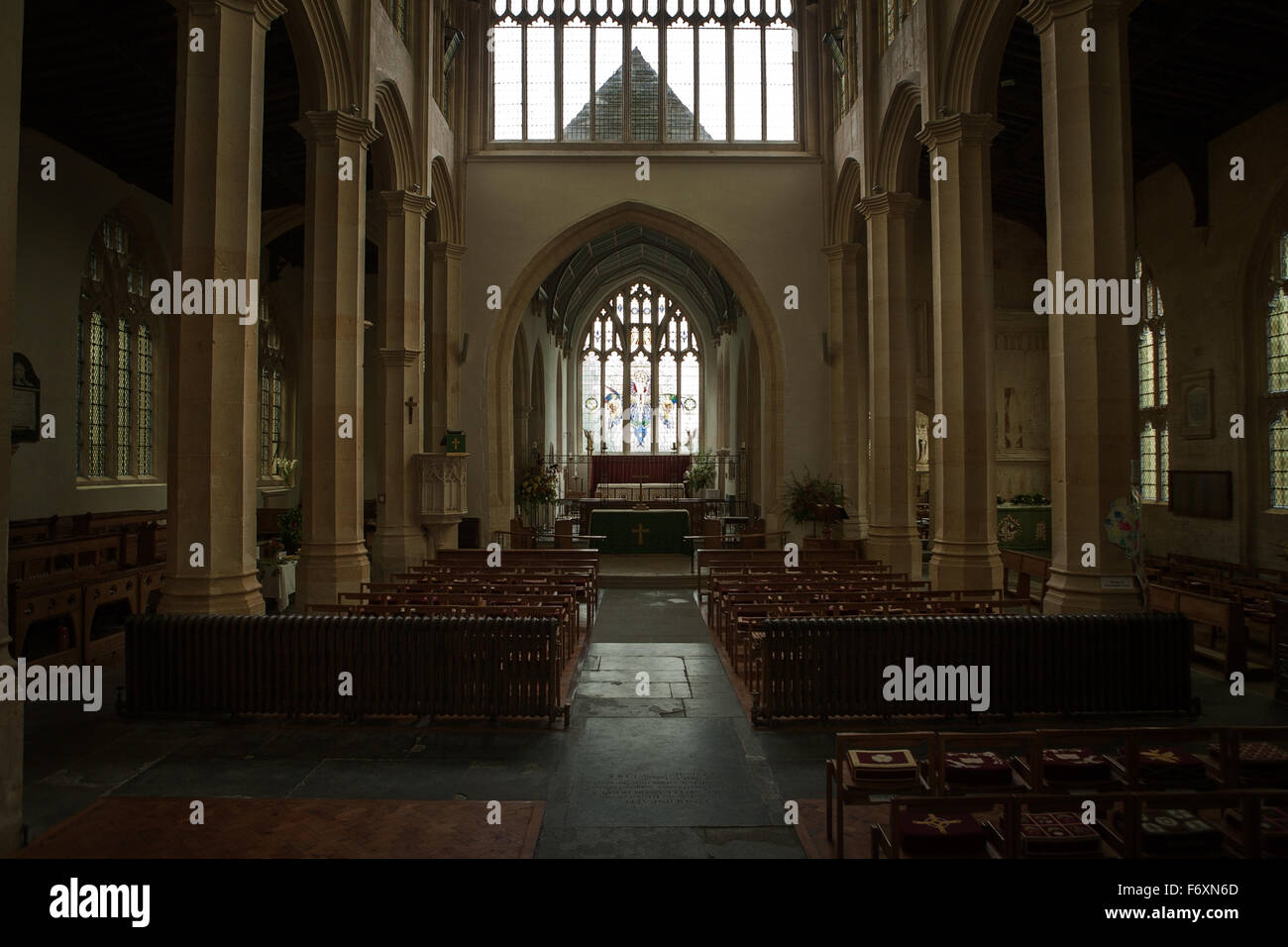 View inside church from back, including pews and stained glass window ...
