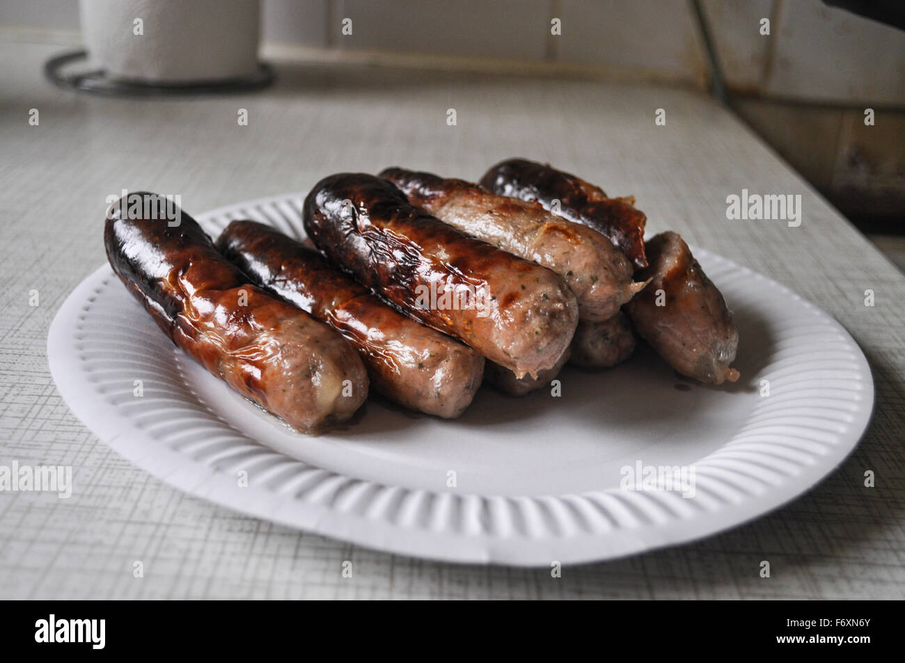 A pile of Cumberland sausages sitting on a paper plate Stock Photo - Alamy