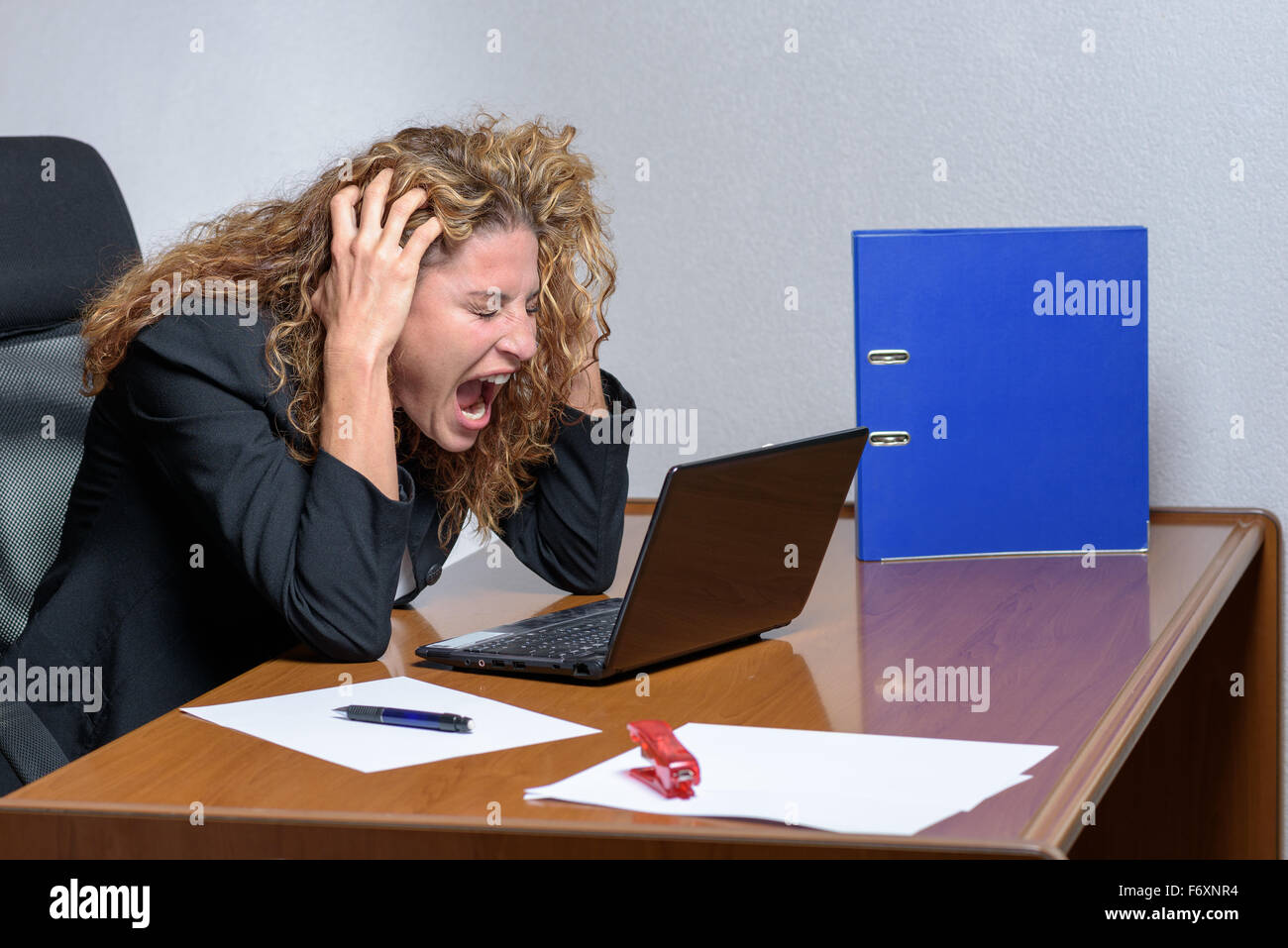 Screaming stylish young businesswoman with a sour expression sitting ...