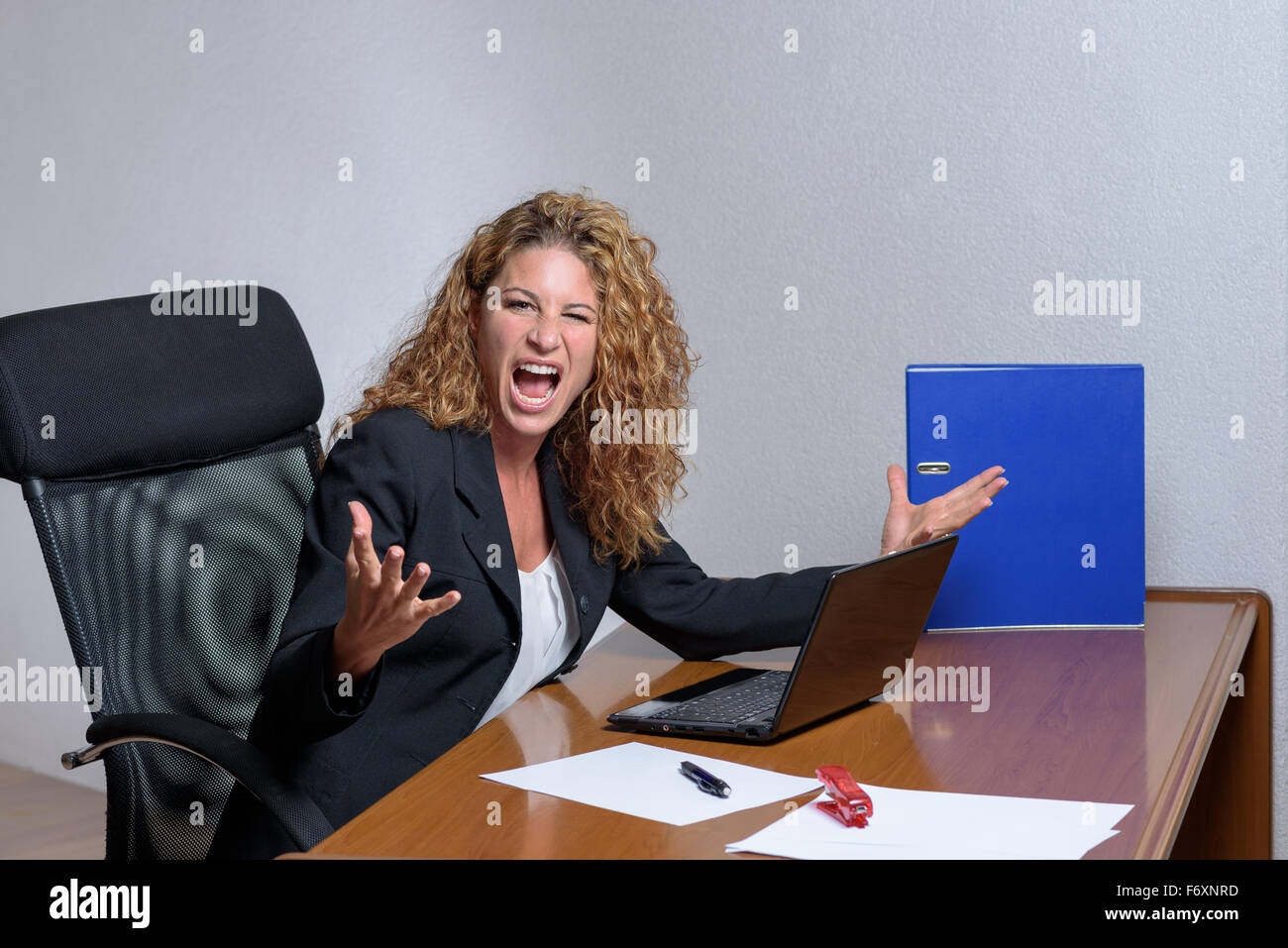 Angry stylish young businesswoman with a sour expression sitting ...