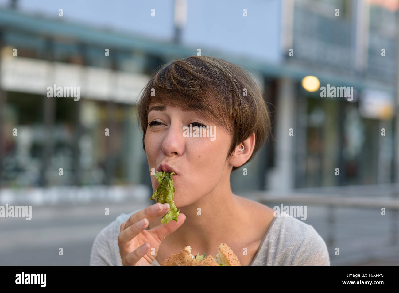 Young woman eating hamburger closeup hi-res stock photography and ...