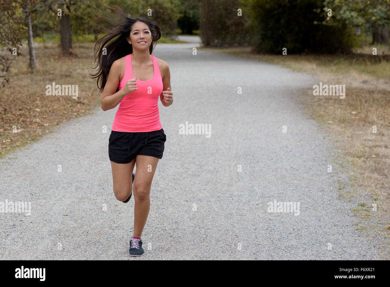 Full length portrait of a fit young woman jogging on a country road ...