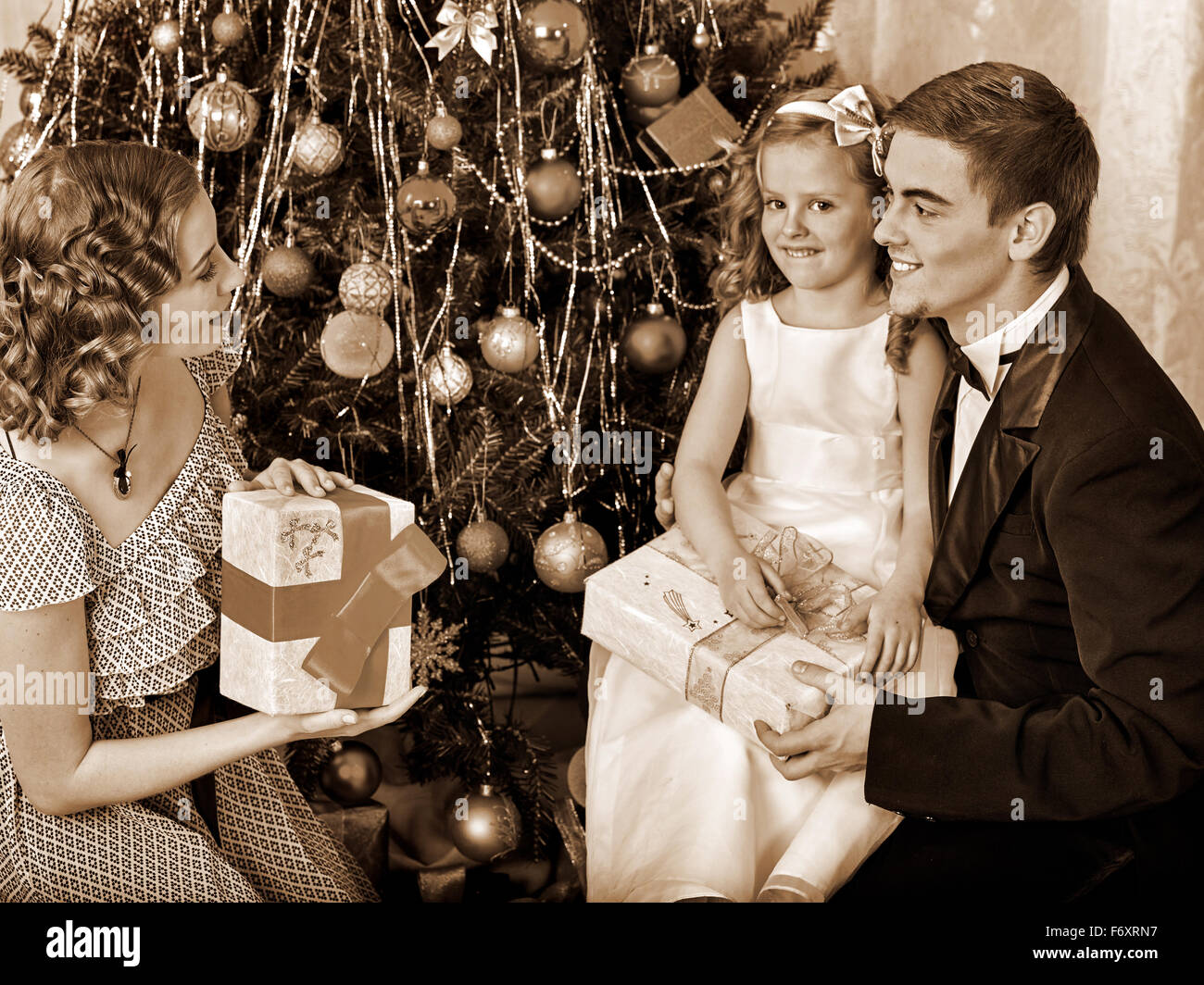 Family with children dressing Christmas tree Stock Photo - Alamy