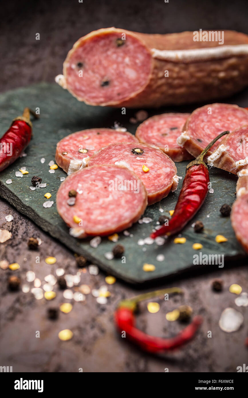 Salami slice with pepper on black slate surface Stock Photo - Alamy