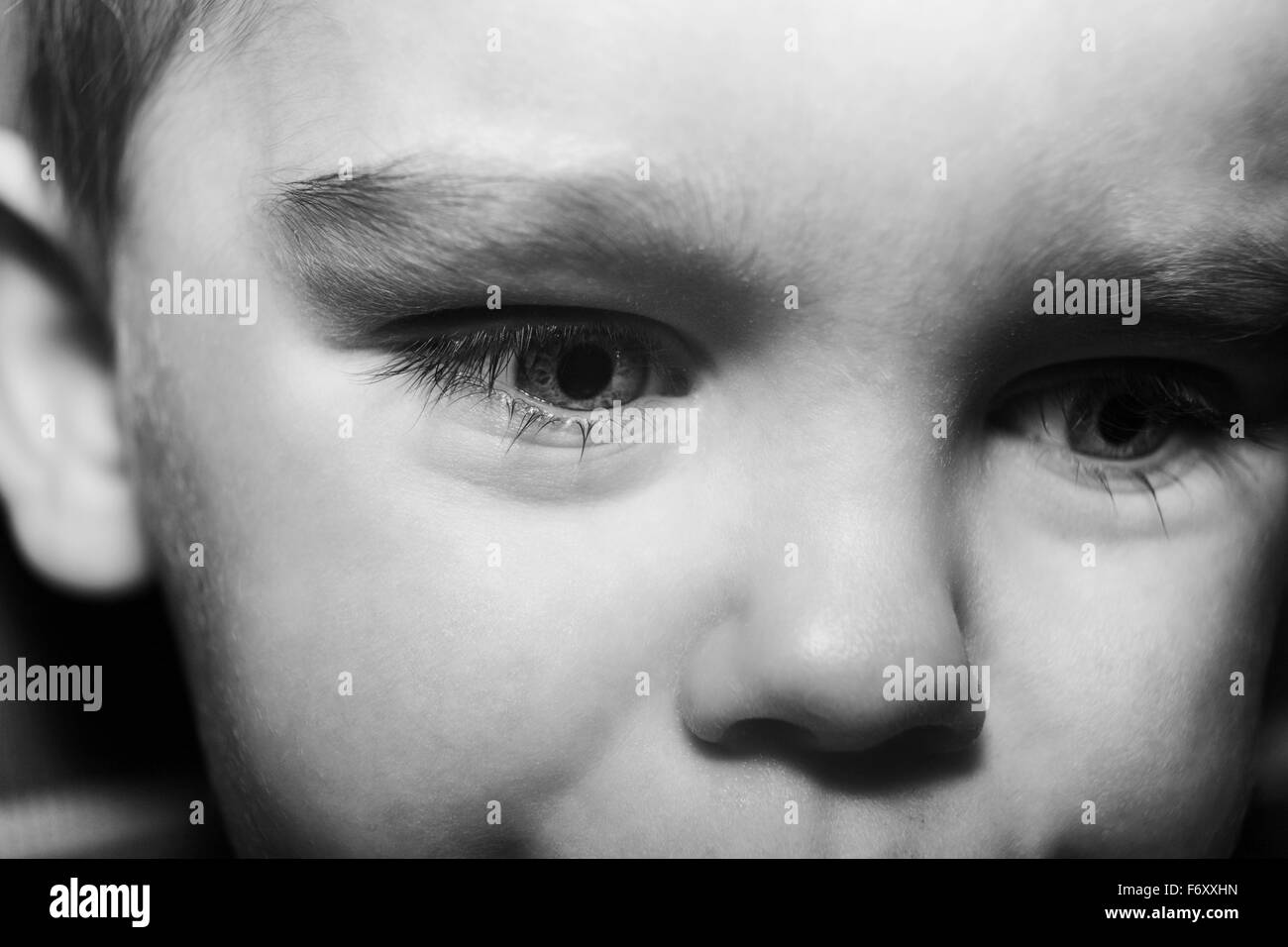 closer up shot of a young boys face not looking happy as if hes about ...