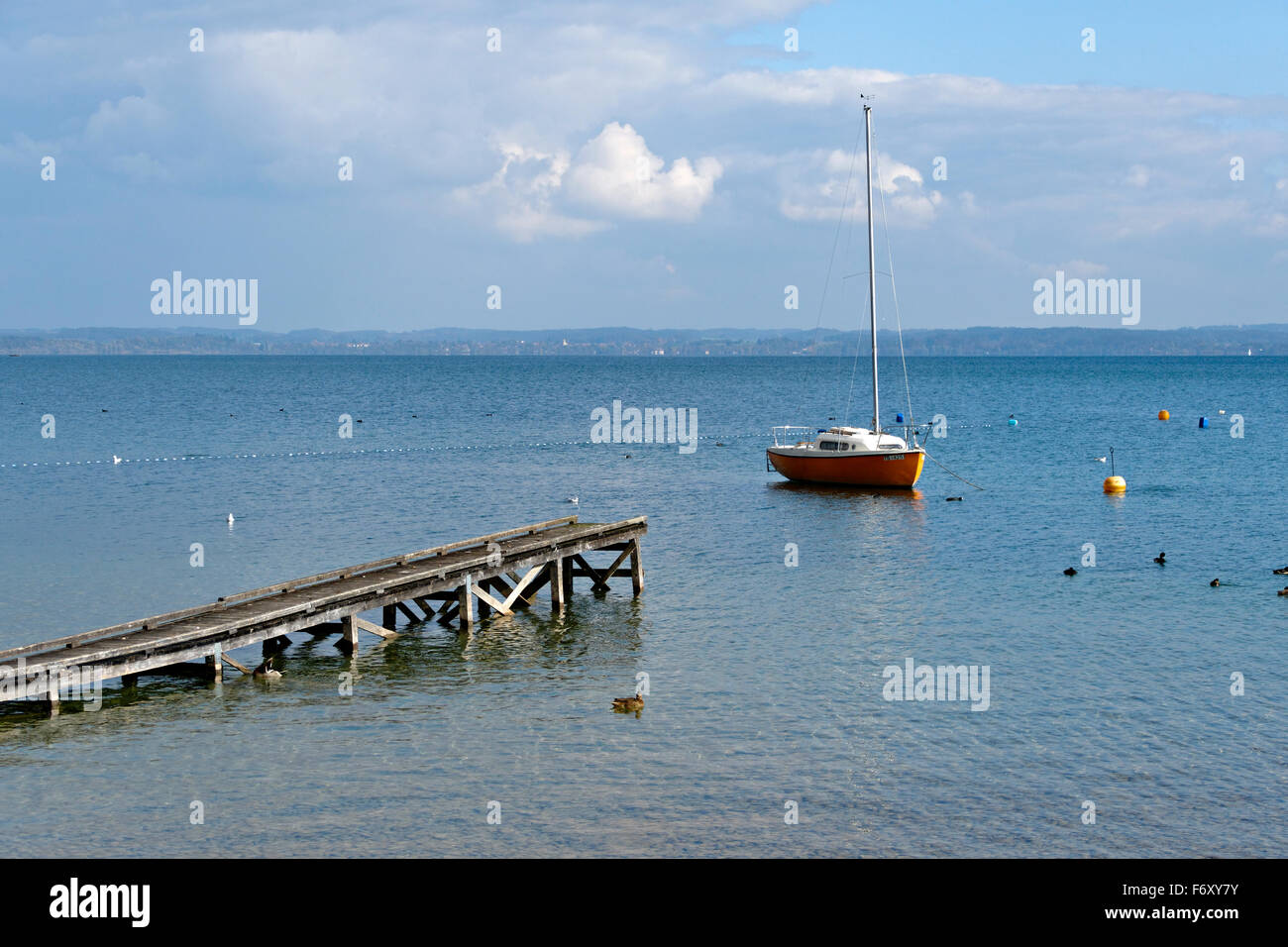 Lake Chiemsee beach foreshore with small boats and pier, Chiemgau ...