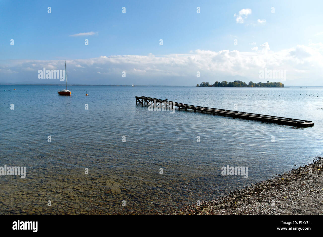 Lake Chiemsee beach foreshore with small boats and pier, Chiemgau ...