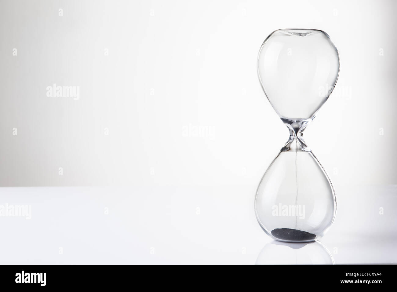 large hour glass sand timer with very little sand in there, time runs ...