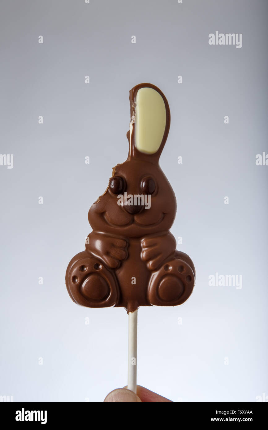 hand holding a chocolate lolly pop in the shape of a rabbit shot in the ...
