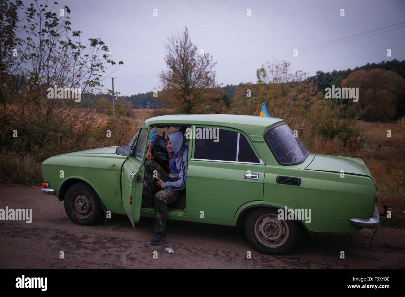 Boy sitting inside green Soviet made car during a road trip in Central ...