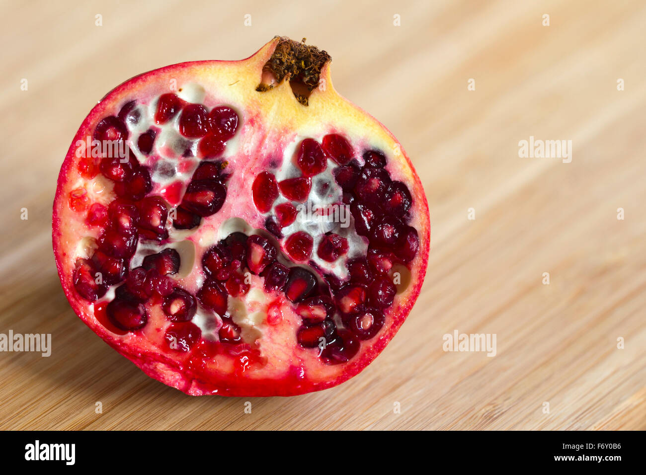 Cross-section of a pomegranate on a wooden chopping board Stock Photo ...