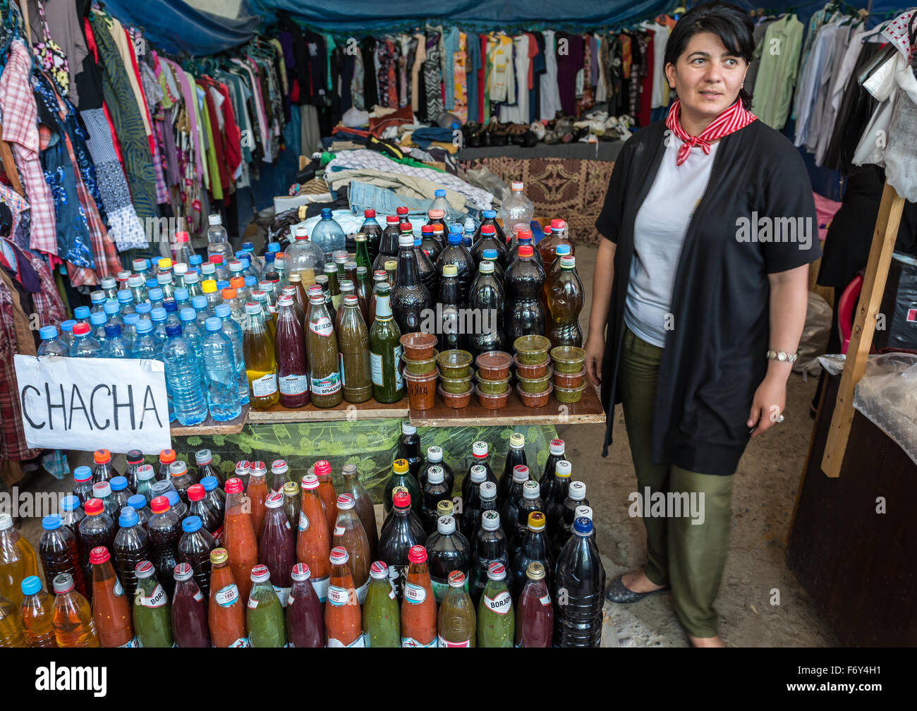 Woman selling homemade chacha, wine and tkemali sauce on market place ...