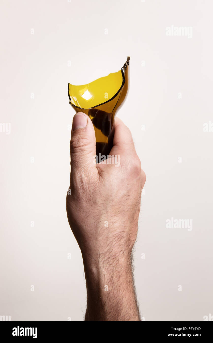 shot from above of a man's hand holding a broken glass bottlen in a ...