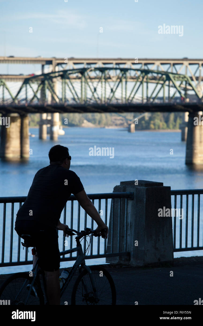 A cyclist bikes along the waterfront in Portland, Oregon Stock Photo ...