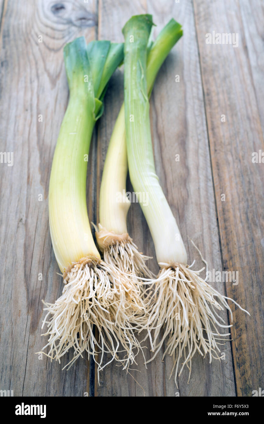 leeks on wooden table Stock Photo - Alamy