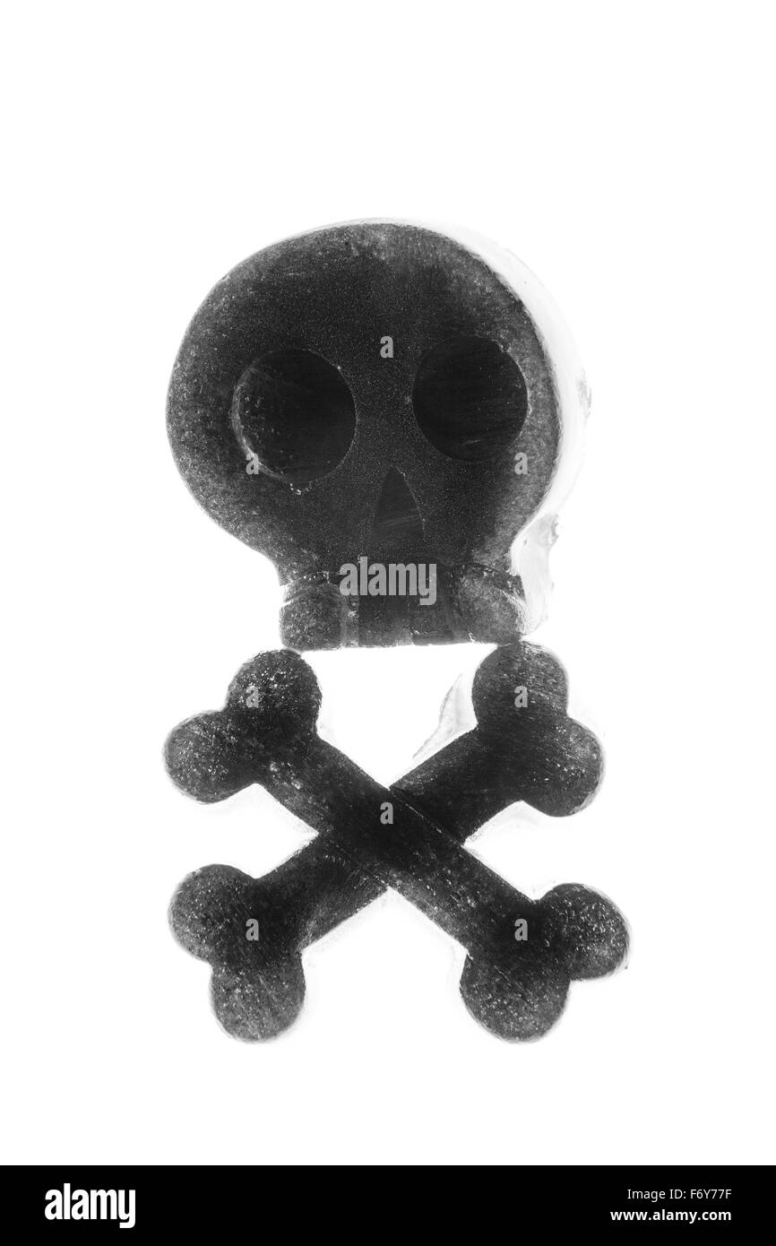 Ice Cube in the shape of a skull and crossbones melting on a white ...