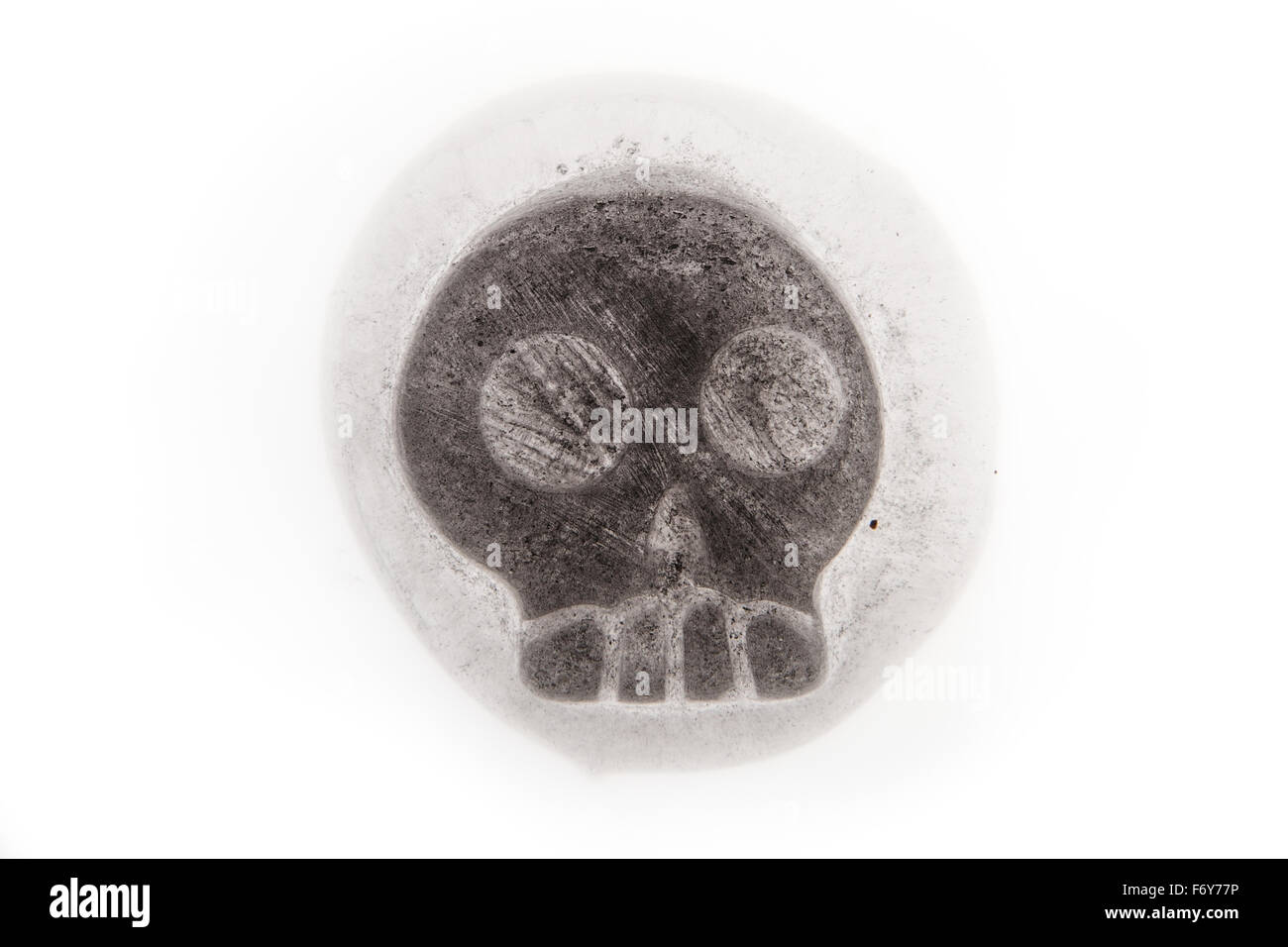 Ice Cube in the shape of a human skull melting on a white background ...