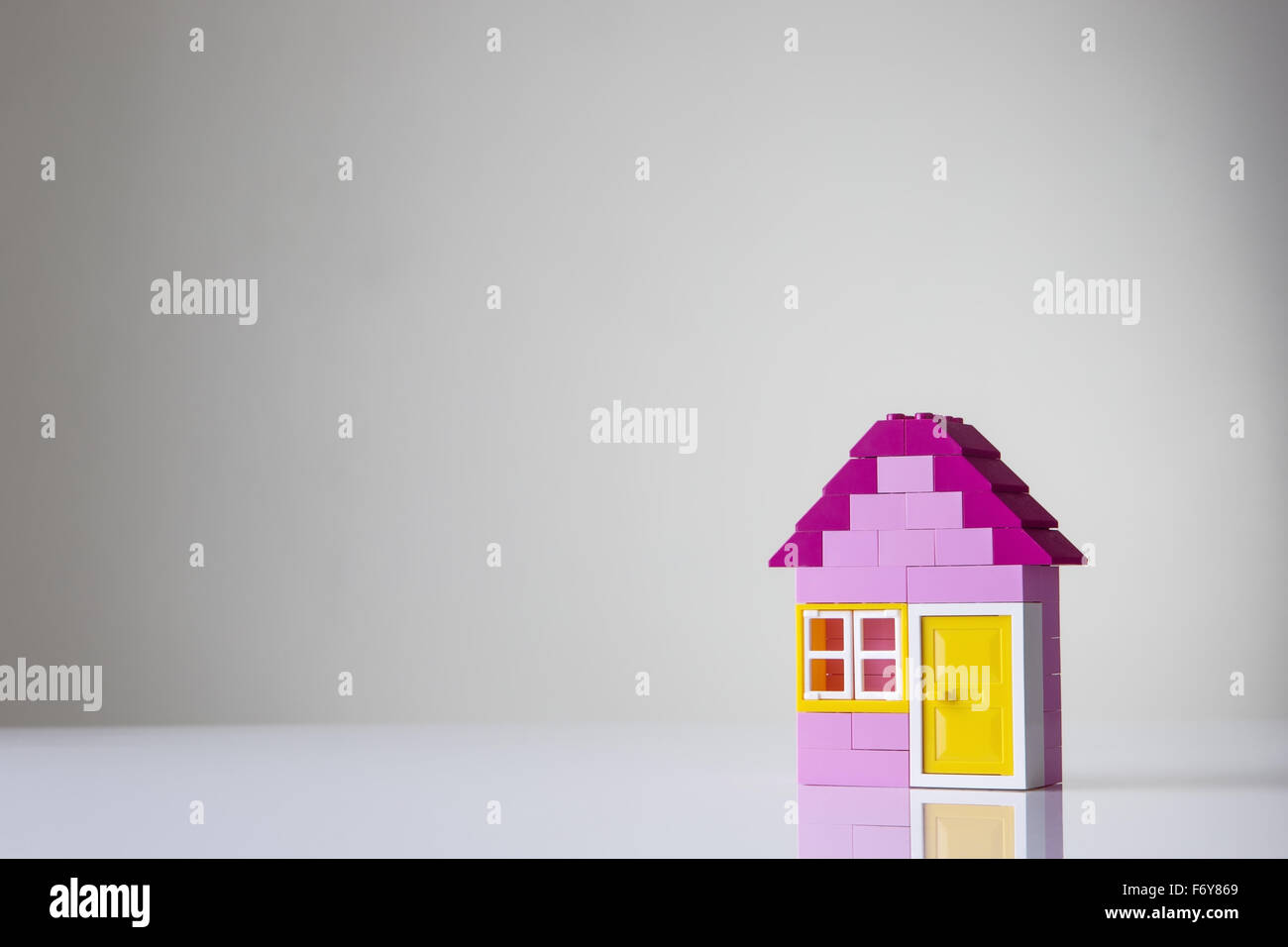 house made of building bricks shot in the studio on white perspex ...