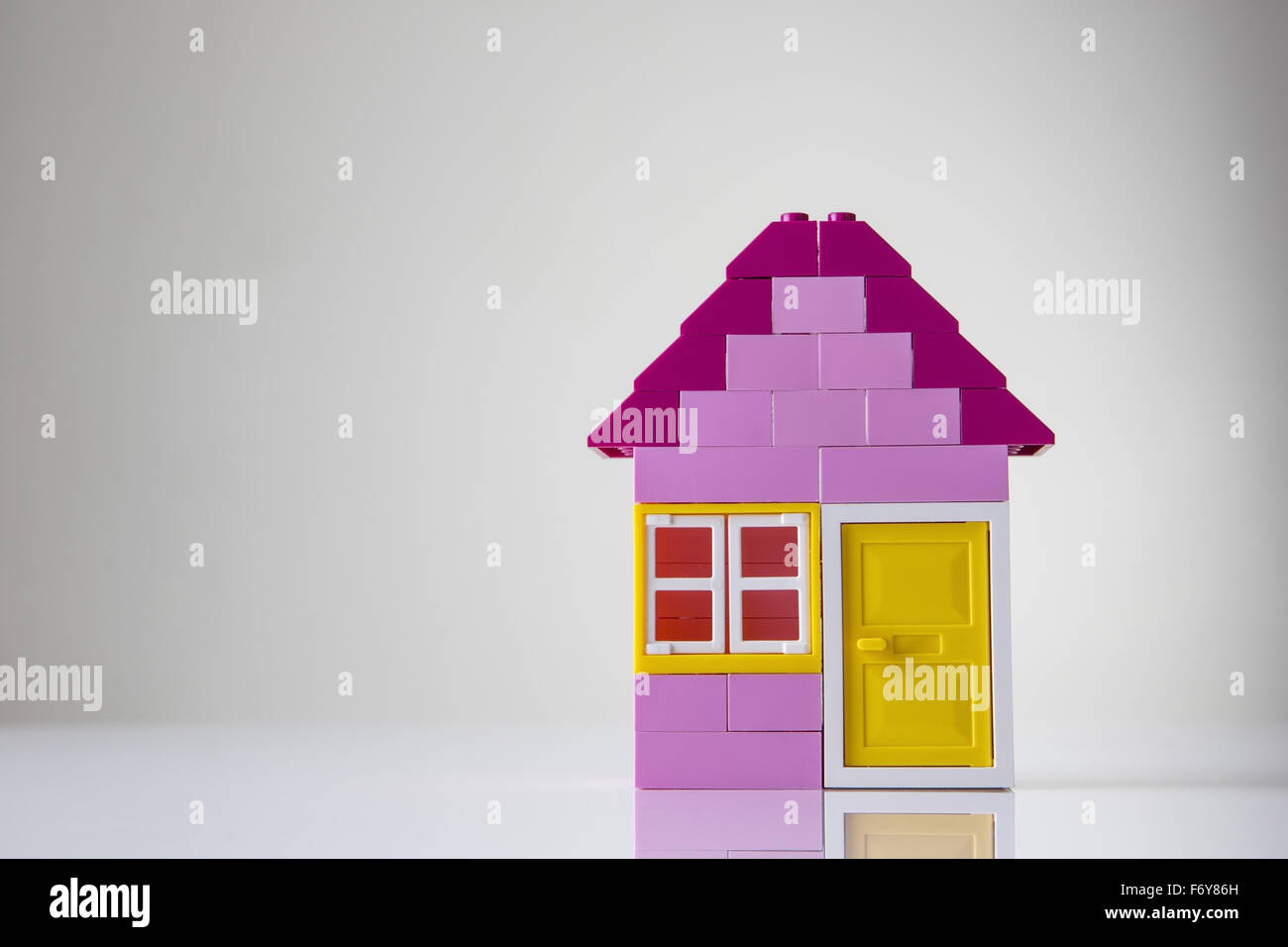 house made of building bricks shot in the studio on white perspex ...