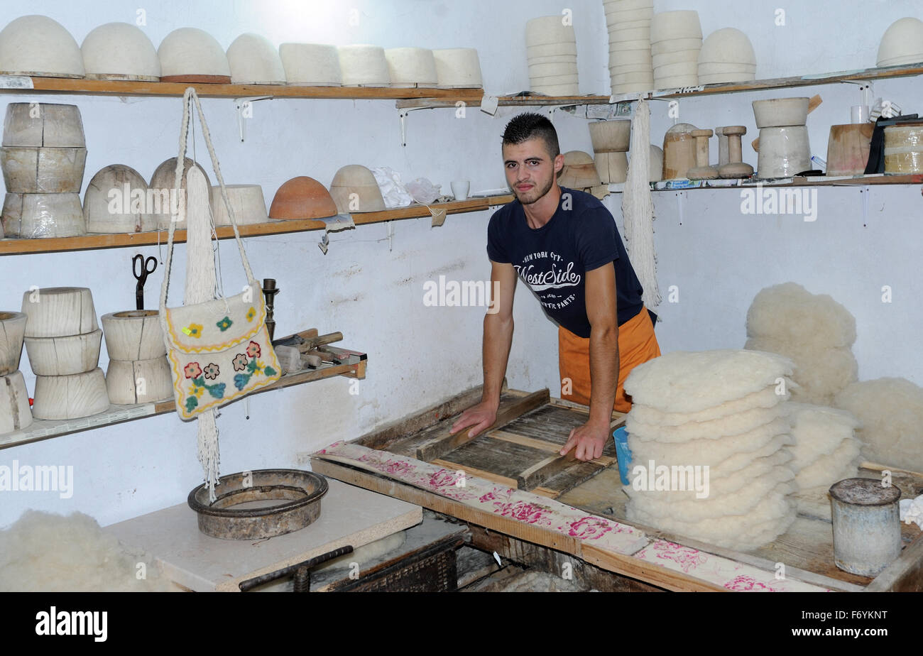A worker in a felt shop moulds the white brimless felt caps (qeleshe or ...