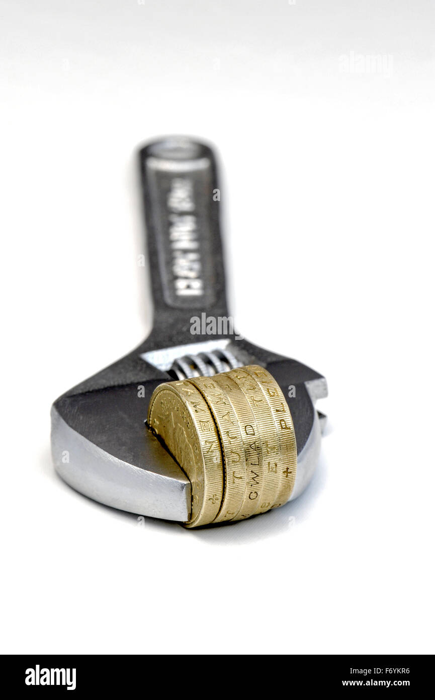 Wrench and coins Stock Photo - Alamy