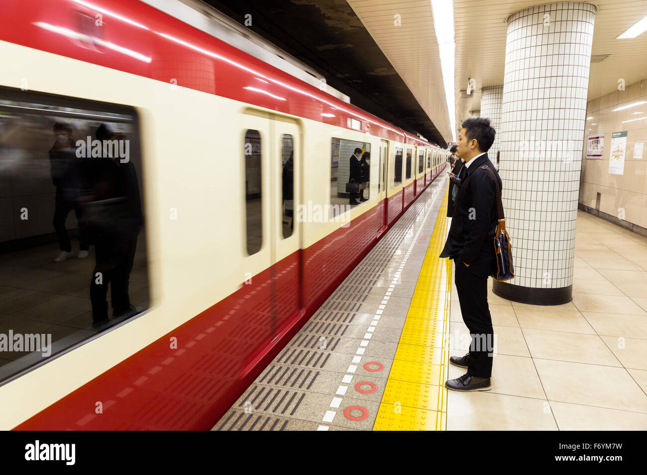 A Japanese man waiting in the underground for a passing train Stock ...