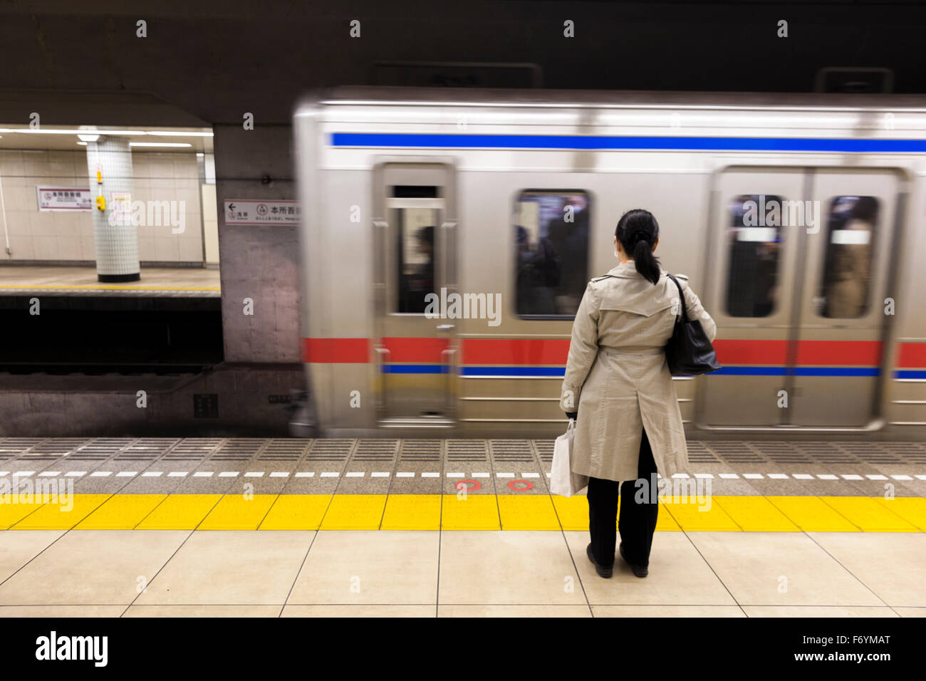 A Japanese woman waiting in the underground for a passing train Stock ...