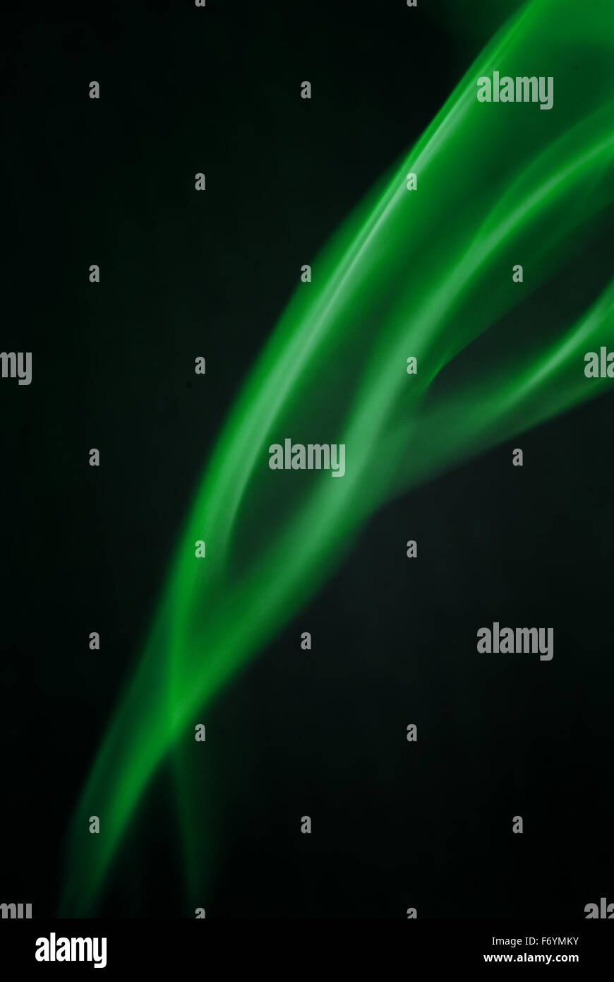 Green abstract incense smoke art on a black background. Symbol of ...