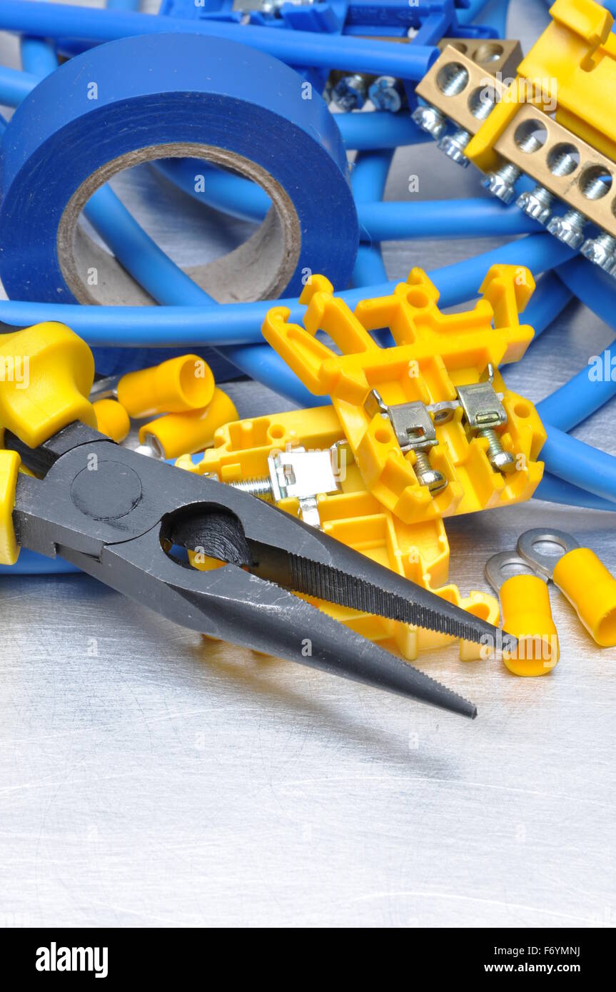 Pliers with electrical component kit on grey metal background with ...