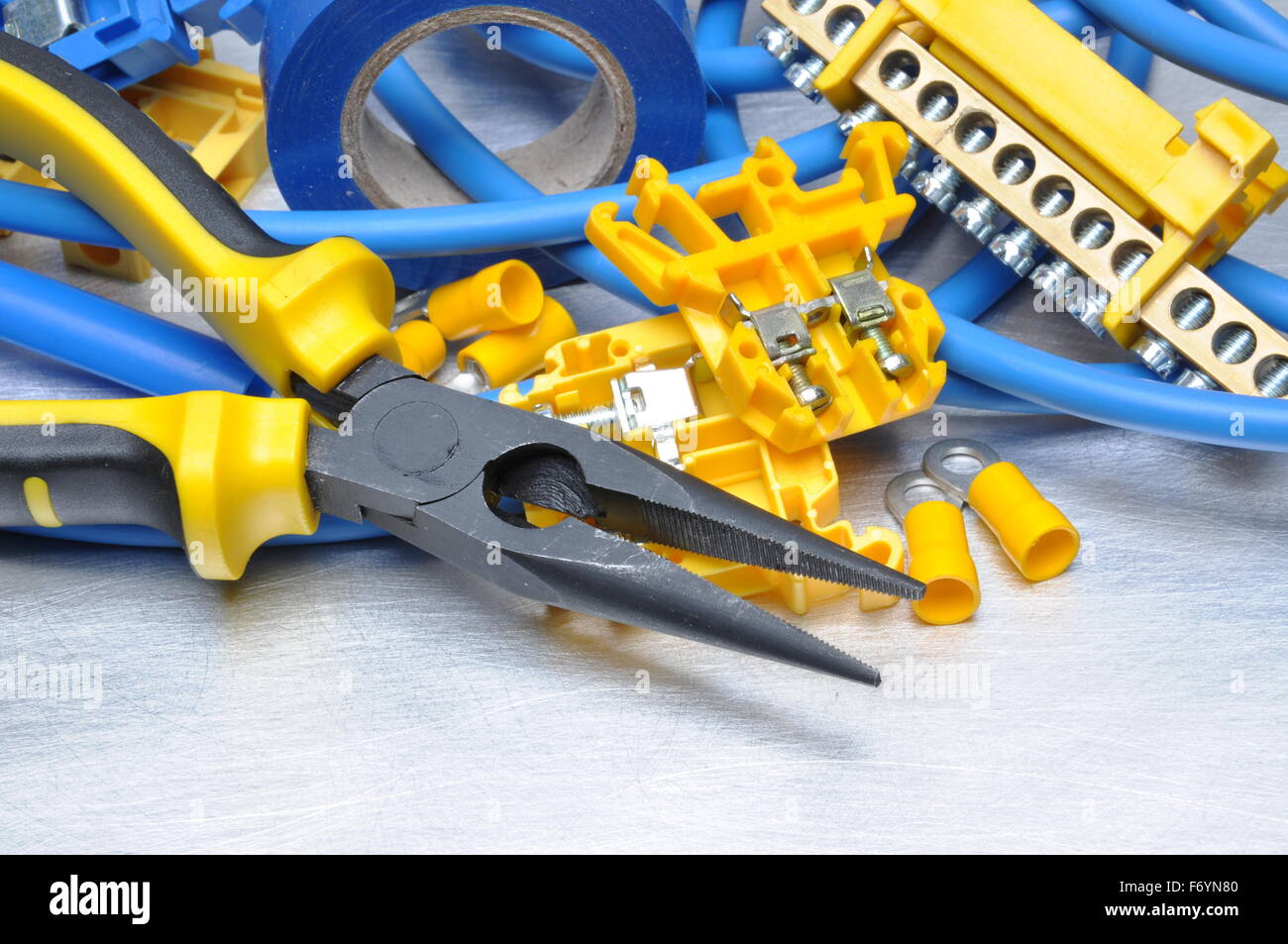 Pliers with electrical component kit on grey metal background with ...