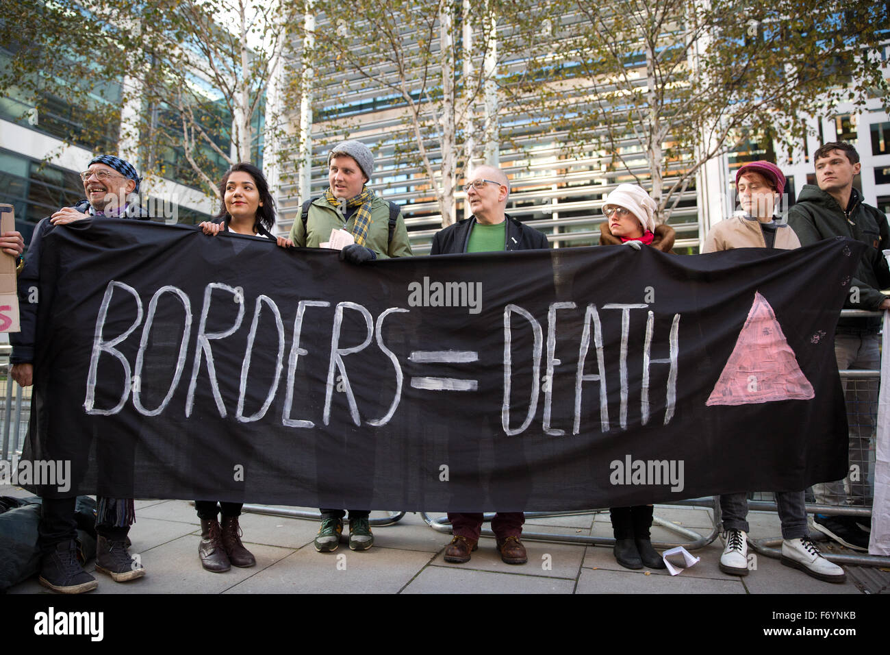 London, UK. 21st Nov, 2015. Activists stand behind a banner reading ...