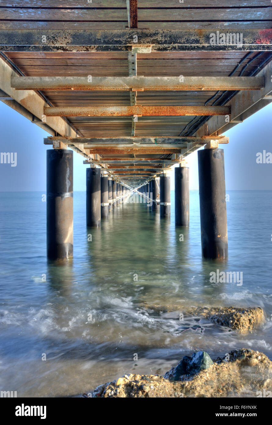 Rusty metallic pier from sea level in vertical composition creating a ...
