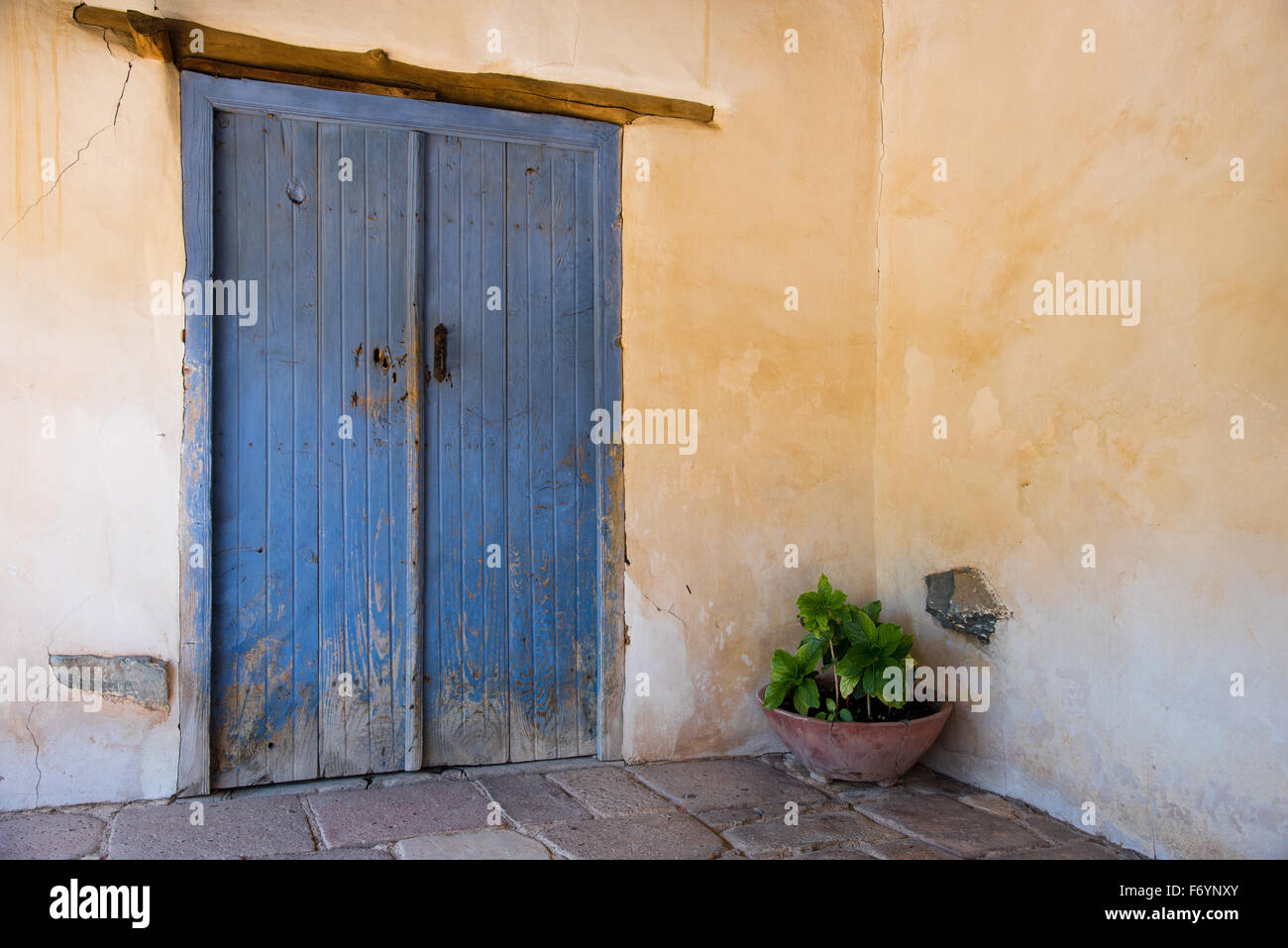 Blue vintage wooden closed door on a courtyard of a traditional Cypriot ...