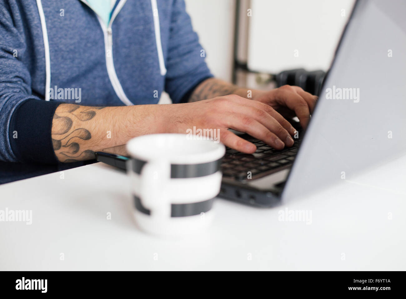 Young man drinking coffee and working Stock Photo - Alamy