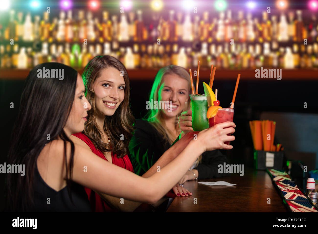 Group of friends at the bar raising their glass of cocktals Stock Photo ...