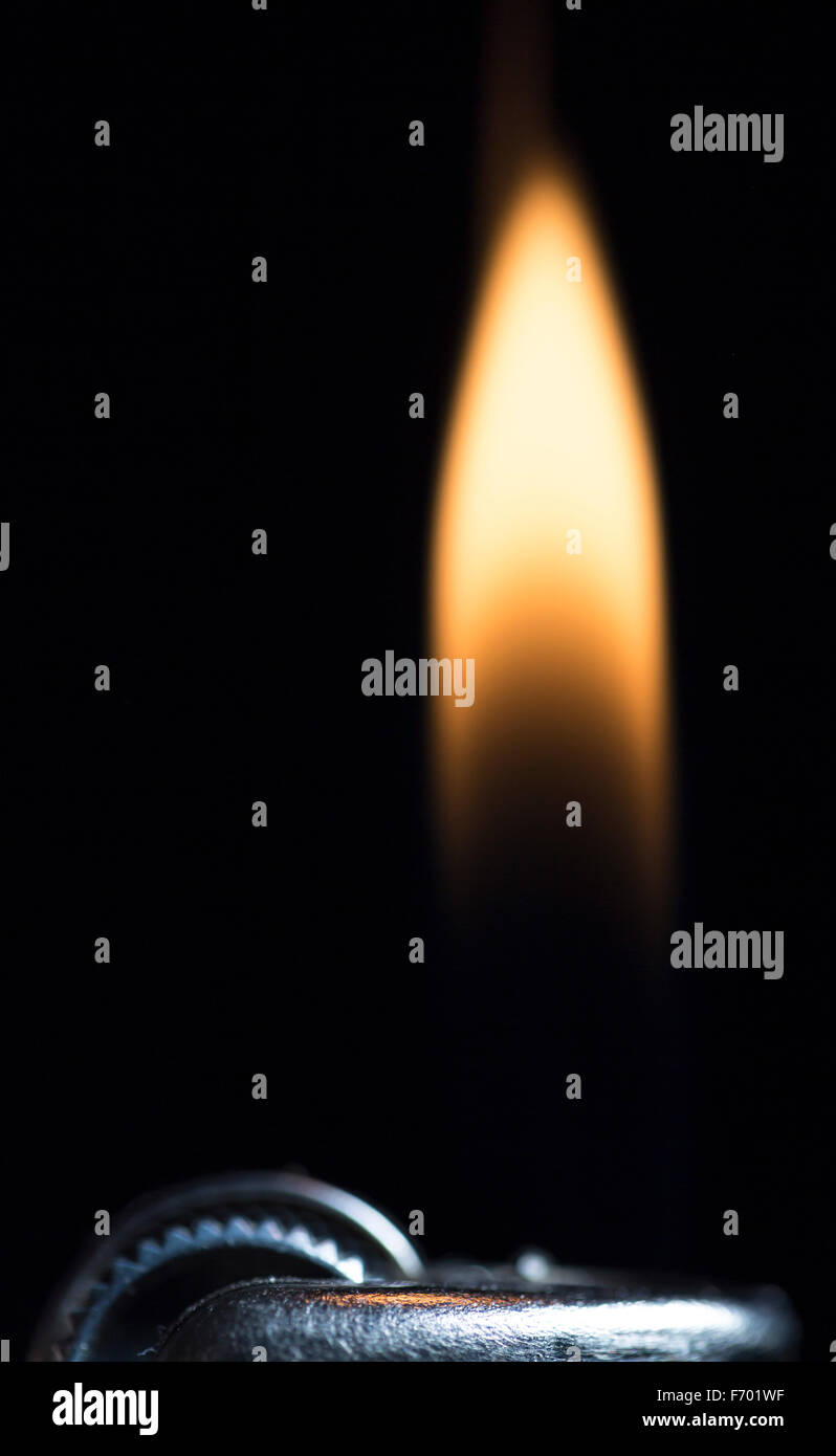 Lighter with Flame close up on black background Stock Photo - Alamy