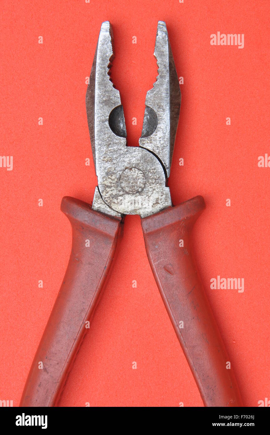 Single combination tool on red background Stock Photo - Alamy