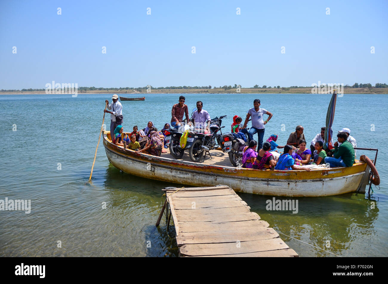 A crowded rowboat departing the dock on Narmada river at Nareshwar ...